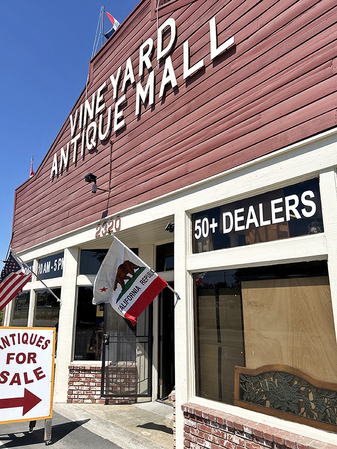 The red-painted facade announces "50+ DEALERS" like a promise of adventure, flying California's bear flag proudly alongside Old Glory.