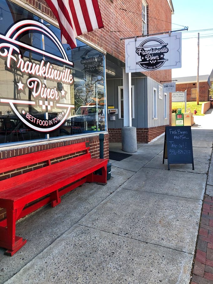 The red bench outside says "Welcome" before you even step inside. Small town charm with a side of American flag&mdash;classic diner DNA.