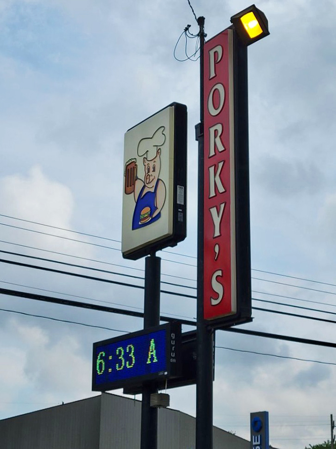 The Porky's sign stands as a beacon of hope for the hungry, its cartoon pig silently promising that diet plans can always start tomorrow.