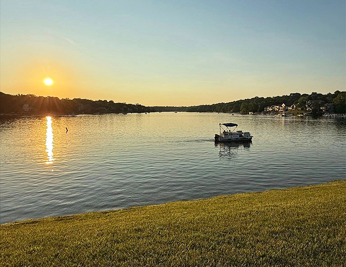 Golden hour transforms an ordinary pontoon into a magical vessel sailing through liquid amber &ndash; no filter needed.