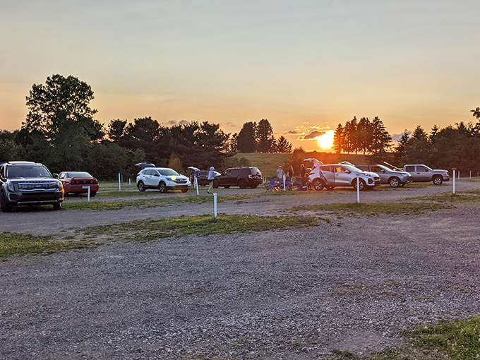 Golden hour at the drive-in, where the setting sun signals the beginning of movie magic rather than the end of the day.