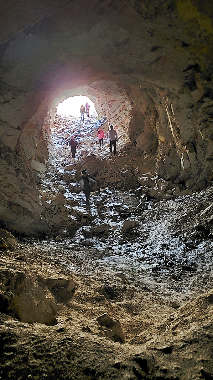 Inside the abandoned railroad tunnel, where echoes of the past meet modern explorers. Like walking through history's hallway with natural skylights.