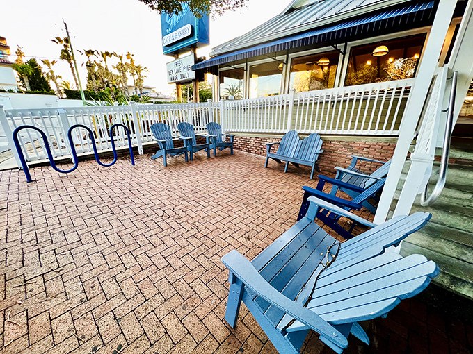 Blue Adirondack chairs await on the brick patio. The perfect spot to contemplate life's big questions, like "Should I order another donut?"