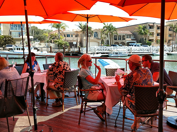 Dining waterfront under bright orange umbrellas - where boats bob in agreement that yes, this is exactly where you should be spending your afternoon.