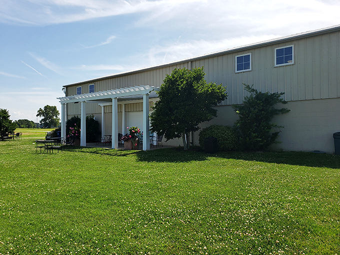 White-flowered clover lawns at Chatham Vineyards & Winery invite you to relax under a classic white pergola on a sunny afternoon.