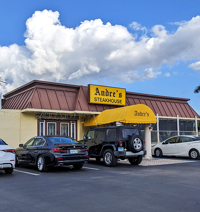 That sunny yellow awning is like a beacon for steak lovers! Andre's stands proud against Florida's blue sky, promising comfort food that'll make your cardiologist wince with delight.