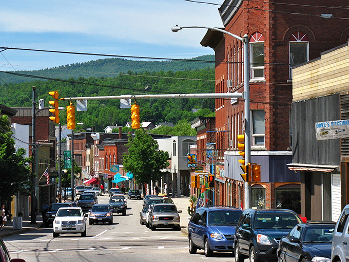 Berlin's historic Main Street showcases classic brick architecture against a backdrop of New Hampshire's majestic mountains.