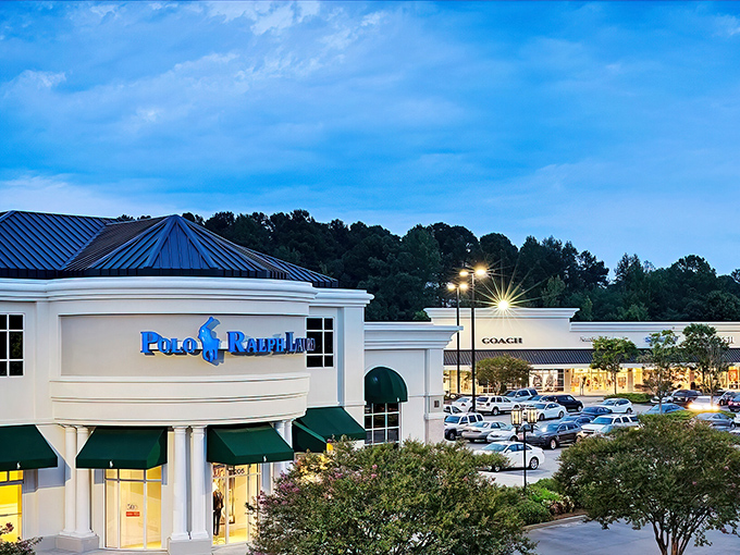 Evening lights transform this outlet paradise into a shopper's wonderland where deals shine brighter than streetlamps.