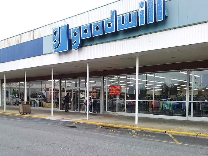 That familiar blue Goodwill sign beckons like a beacon to bargain hunters everywhere, promising treasures within.