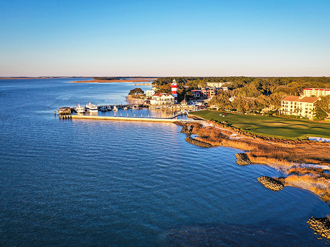 Harbor heaven! Where red-and-white lighthouse dreams meet blue-water reality at Hilton Head's postcard-perfect marina. Like finding Mayberry with yachts!