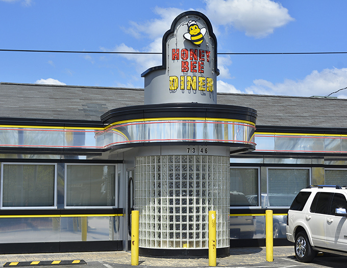 That cheerful bee mascot promises sweet mornings ahead at this gleaming chrome diner destination.