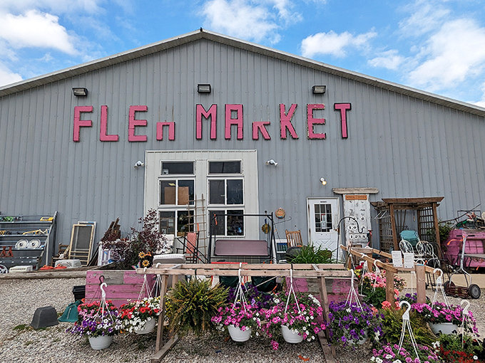 That bright pink "FLEA MARKET" sign practically shouts "treasures inside!" - and those colorful flower displays don't lie.