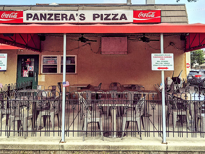 That classic red awning beckons like a pizza lighthouse, promising cheesy treasures within those welcoming walls.