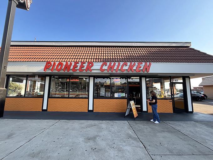 That classic red Pioneer Chicken sign promises golden treasures waiting inside this humble Los Angeles gem.