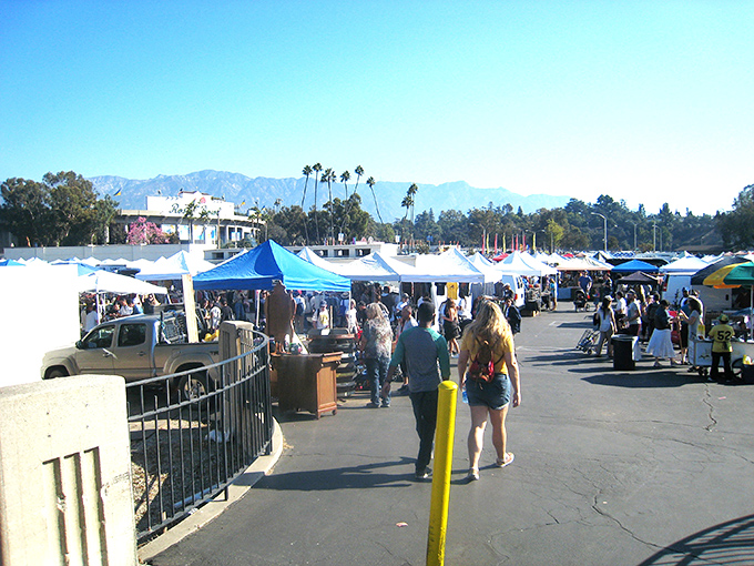 Treasure hunters navigate the sprawling Rose Bowl Flea Market, where blue canopies stretch toward the mountains like a bargain-seeker's mirage.
