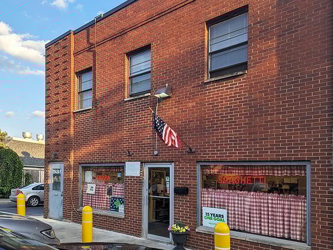 Rubino's brick exterior is like a time machine with checkered curtains. That neon "SPAGHETTI" sign has been calling pizza lovers for generations.