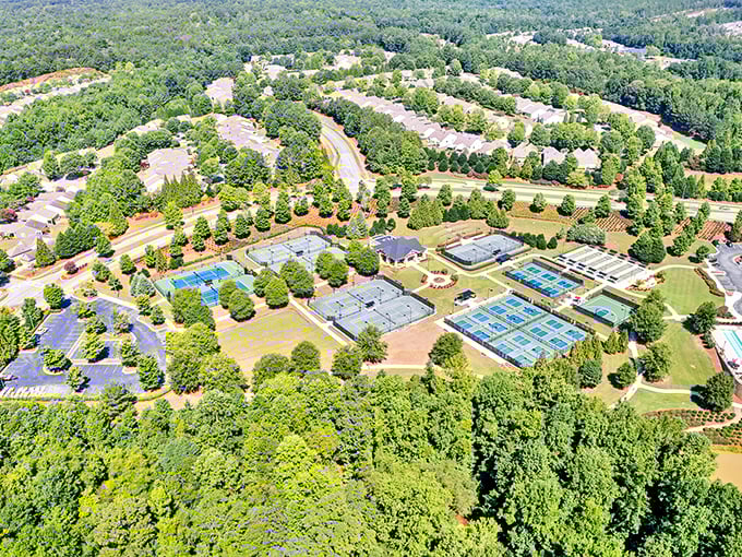 Aerial paradise! Sun City Peachtree's tennis courts, pickleball courts, and swimming pool look like a resort brochure come to life.