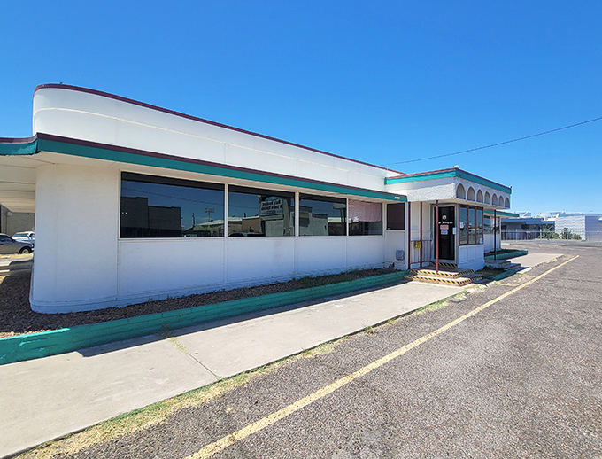 The classic white-and-teal exterior of Mel's Diner stands like a time capsule against the Arizona sky, beckoning hungry travelers with promises of comfort food.