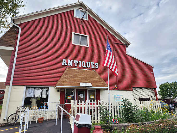 The big red barn of Volo Antique Malls stands like a patriotic time capsule, beckoning treasure hunters with its charming white picket fence.