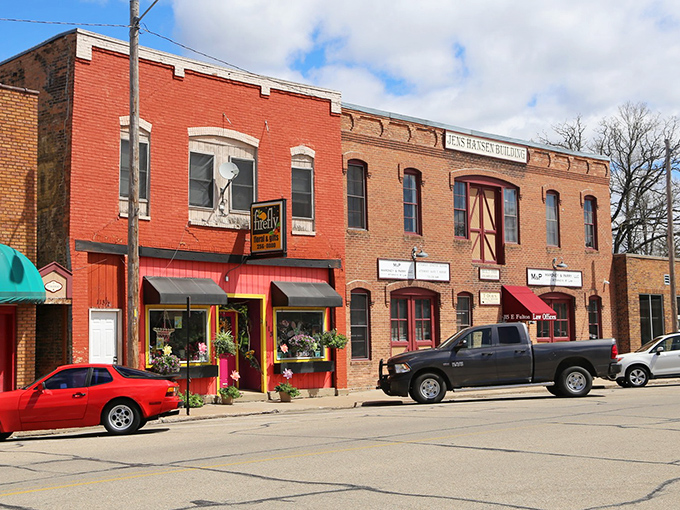 Classic brick storefronts line up like old friends sharing stories, their colorful awnings beckoning visitors to slow down and browse.