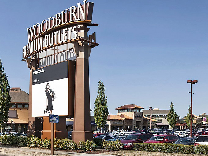 The towering Woodburn Premium Outlets sign stands like a beacon for bargain hunters. Shopping paradise awaits!