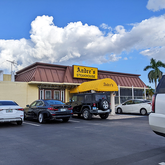 The classic steakhouse exterior with its distinctive yellow awning has welcomed hungry Naples diners for generations.