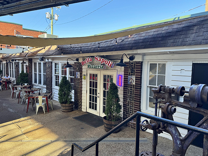 Outdoor dining under string lights at Bella Napoli. Pizza tastes better when enjoyed in a courtyard that whispers "Italy."