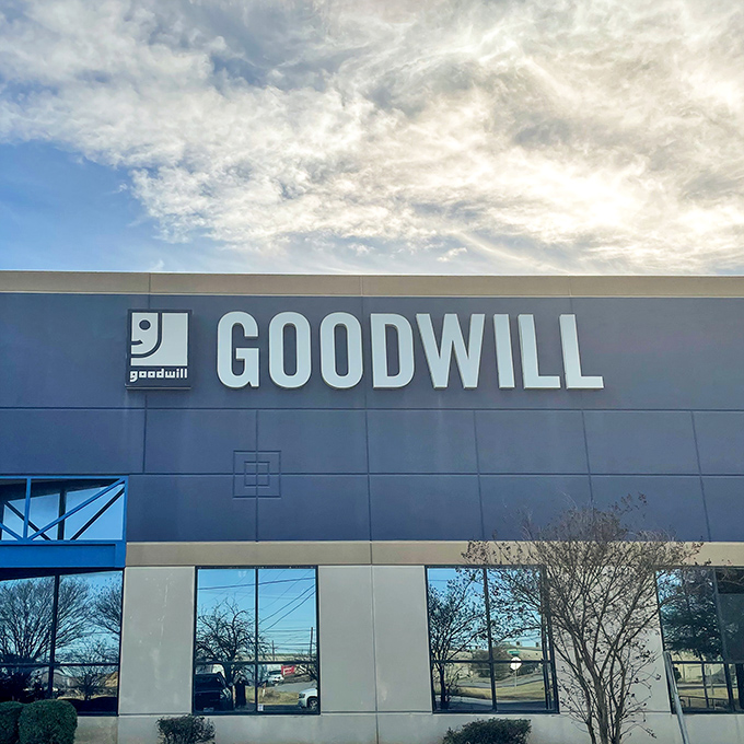 Blue skies, big savings. Goodwill's impressive facade stands ready for thrift hunters seeking that perfect unexpected find.