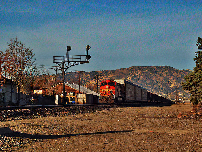 All aboard the nostalgia express! This mighty red locomotive snakes through Tehachapi's dusty landscape like a scene from your grandfather's favorite Western.