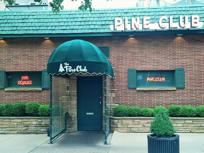 The Pine Club's iconic green awning and brick exterior &ndash; like a secret clubhouse where the password is "medium-rare."