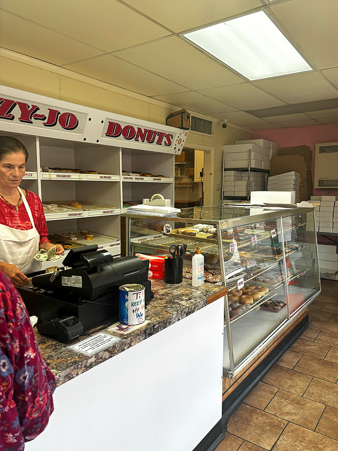Behind the counter, where donut magic happens daily. The display cases hold treasures more valuable than gold to those with a proper appreciation for breakfast.