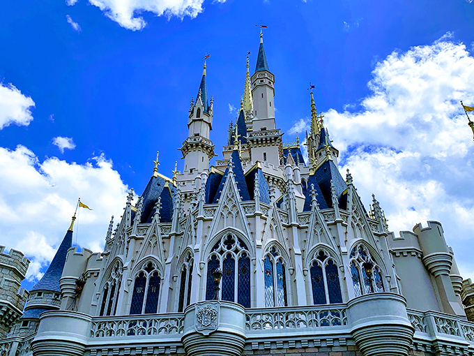 Gothic arches and soaring spires reach toward a perfect Orlando sky, making you wonder if medieval architects missed their calling in theme park design.