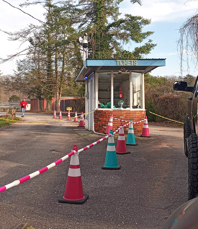 The humble ticket booth stands as a time portal to simpler pleasures, complete with traffic cones that have probably directed more family memories than any GPS ever could.