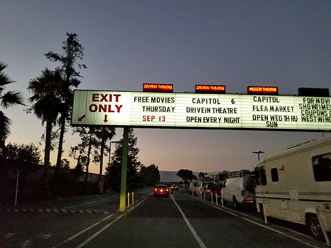 The iconic entrance sign glows against the dusk, promising "FREE MOVIES THURSDAY" and announcing the weekend flea market&mdash;a beacon of entertainment options.