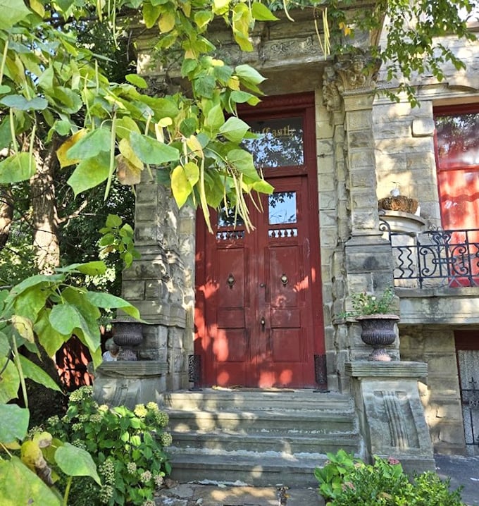 The crimson door beckons visitors through stone archways draped with greenery – nature's attempt to soften what might be Ohio's most intimidating welcome mat.