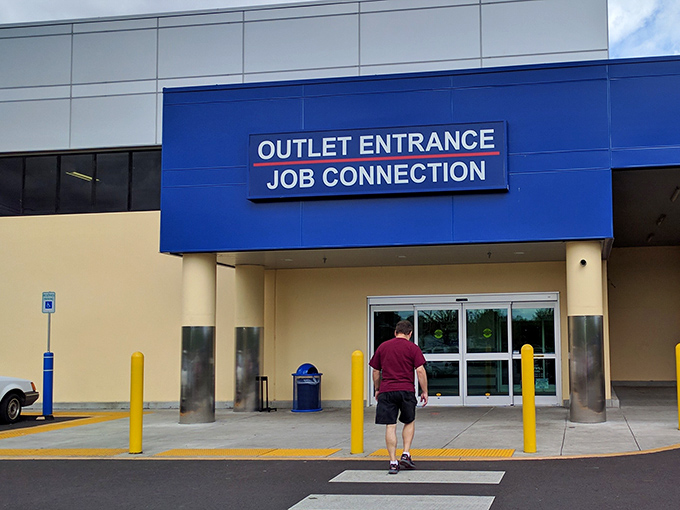 The blue "Outlet Entrance" sign might as well read "Abandon All Shopping Budgets, Ye Who Enter Here." Your thrifting adventure begins here.