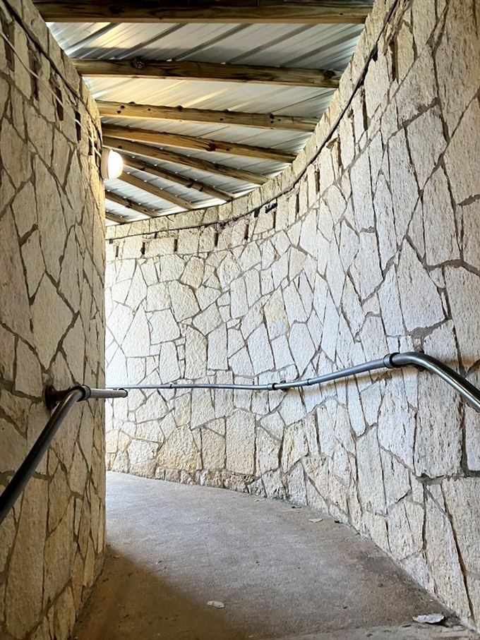 The entrance pathway feels like the portal to a fantasy realm. This curved stone corridor is your last glimpse of the ordinary before the extraordinary unfolds.
