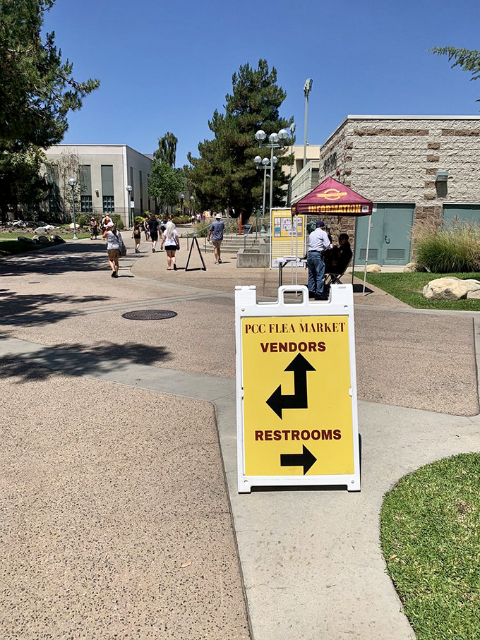 The yellow directional sign says it all&mdash;vendors this way, restrooms that way. The universal language of flea market navigation never fails.