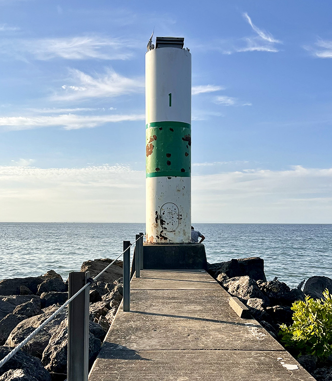 This nautical sentinel stands guard where lake meets sky, a weathered maritime landmark that's seen more sunsets than most of us have had hot dinners.
