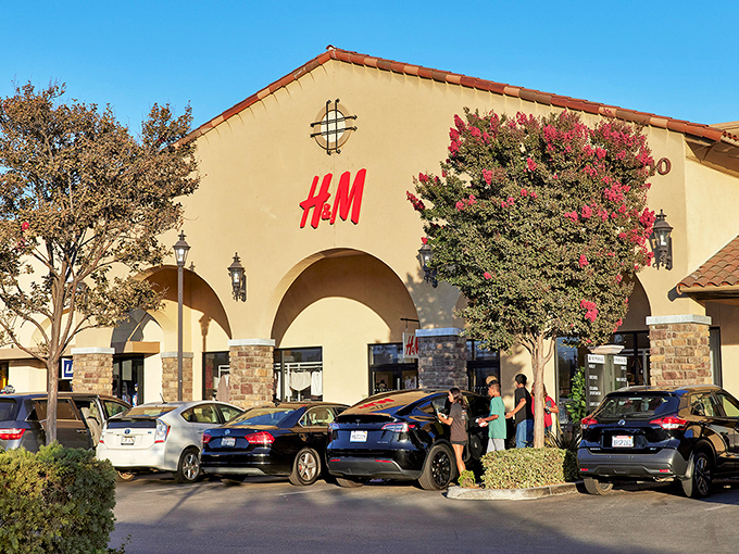 H&M's bright red sign beckons like a fashionable lighthouse, guiding style-seekers to shores of affordability amid a sea of California sunshine.