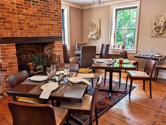 Exposed brick walls meet elegant table settings in this dining room where history and hospitality share the same comfortable chair.