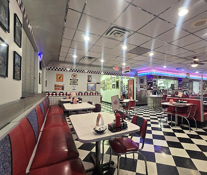 Step inside and the 1950s never ended. Black and white checkered floors, red vinyl booths, and neon lighting create the perfect retro atmosphere.