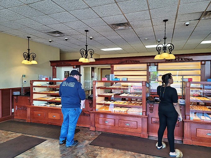 Decisions, decisions! The wood-paneled display cases house decades of baking tradition, where customers contemplate life's most important question: one donut or two?