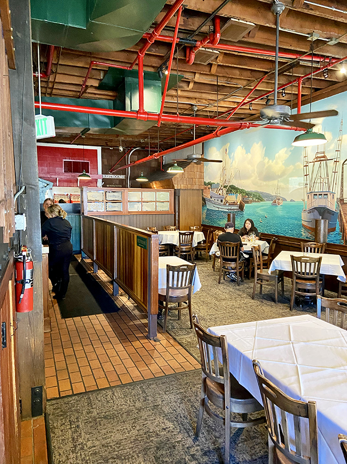 Step inside and discover a maritime wonderland where exposed wooden beams, red pipes, and that stunning harbor mural transport you to a seaside haven.