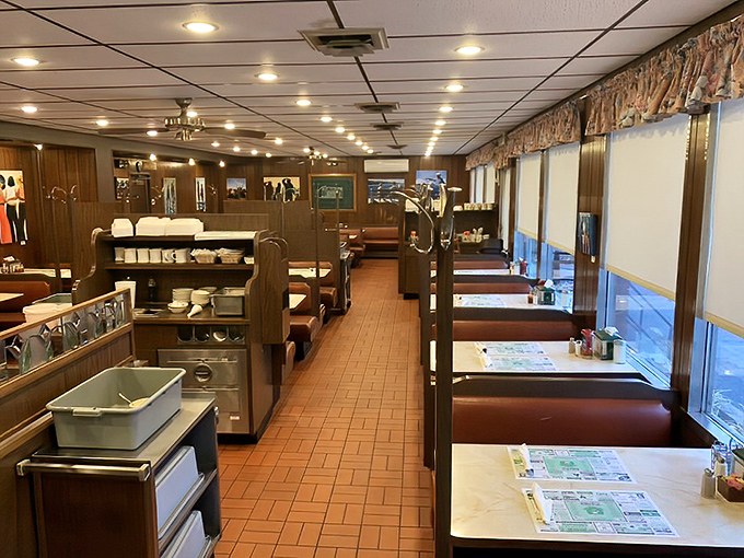 The diner's interior stretches like a runway of comfort, where every booth promises the possibility of breakfast at any hour.