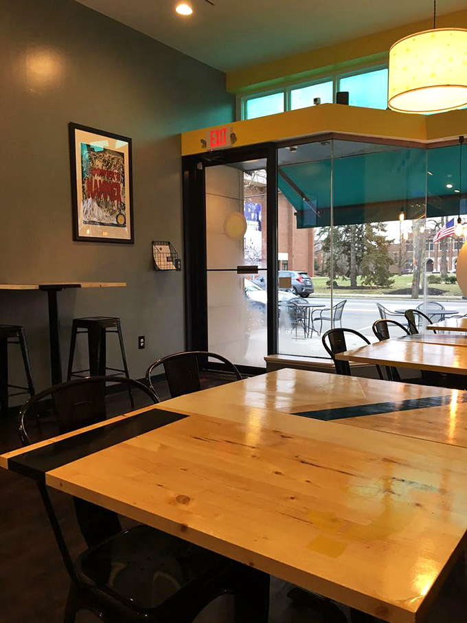 Warm wooden tables paired with industrial-chic chairs create the perfect backdrop for sandwich artistry. Like a well-dressed date, this interior impresses without trying too hard.