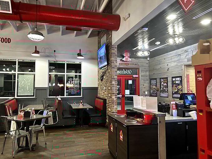 Industrial chic meets Southern comfort in this dining space where red accents and exposed brick create the perfect backdrop for chicken-induced euphoria.