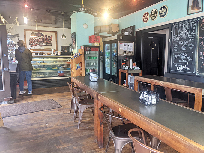 Inside, the mint-blue walls and wooden communal tables create that rare atmosphere where strangers become friends united by the universal language of great sandwiches.