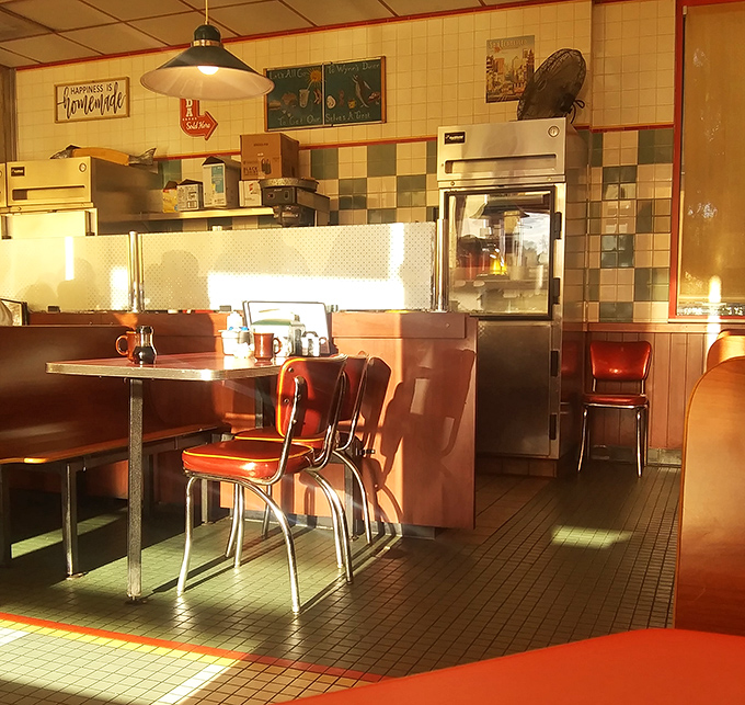 Morning sunlight transforms this classic diner interior into a time capsule of Americana, where red vinyl and checkered tiles tell stories of countless breakfasts past.