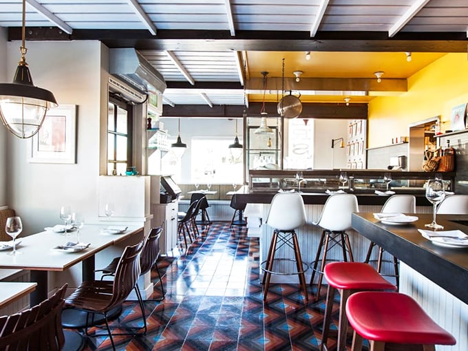 Coastal chic meets neighborhood joint in this intimate space. Those geometric floor tiles and white Eames barstools say "we're stylish, but we don't need to brag about it."